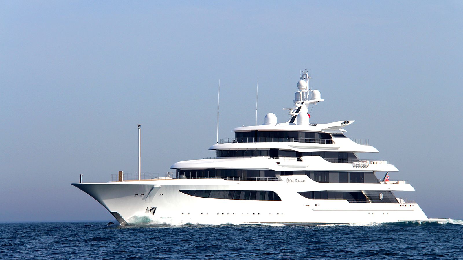 Dolphins play off bow of superyacht Royal Romance on her maiden voyage